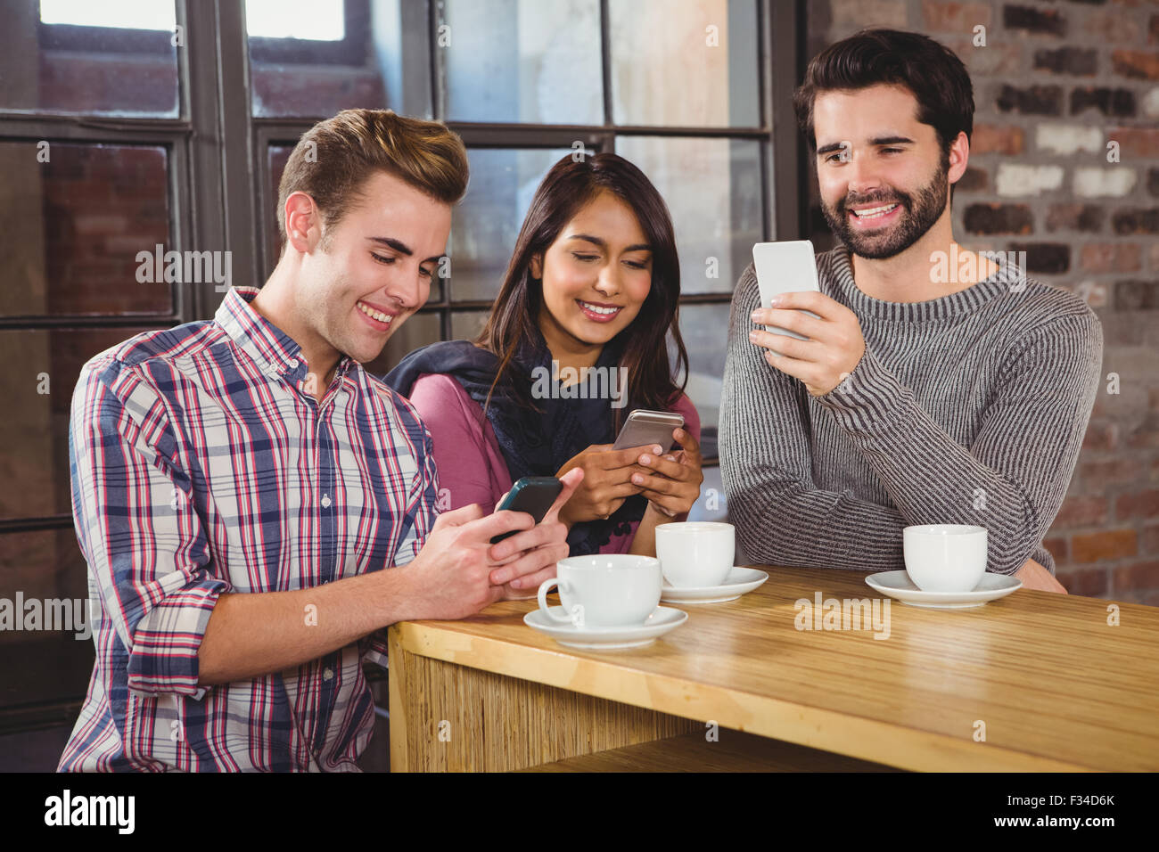 Group of friends looking at their smartphone Stock Photo - Alamy