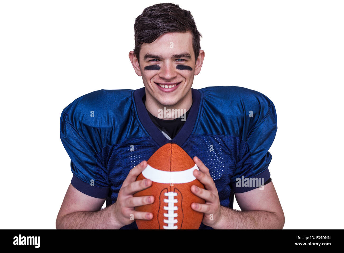 Smiling american football player holding a ball Stock Photo - Alamy