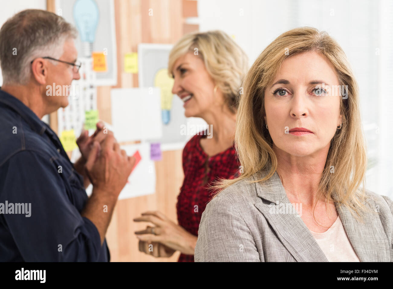 Stern businesswoman ahead with her team behind Stock Photo - Alamy