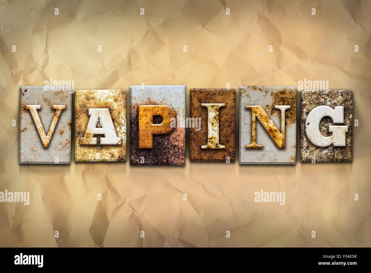 The word "VAPING" written in rusty metal letterpress type on a crumbled ...