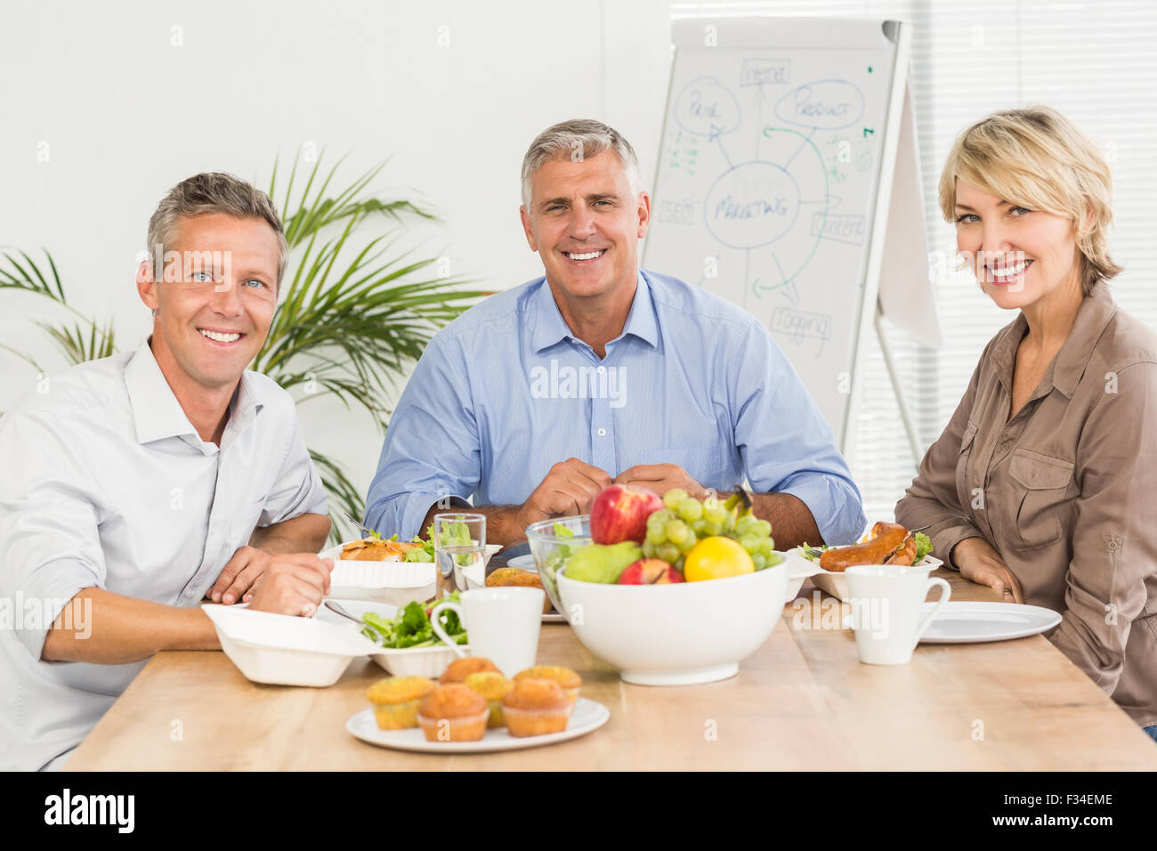 Smiling business colleagues having lunch together Stock Photo - Alamy