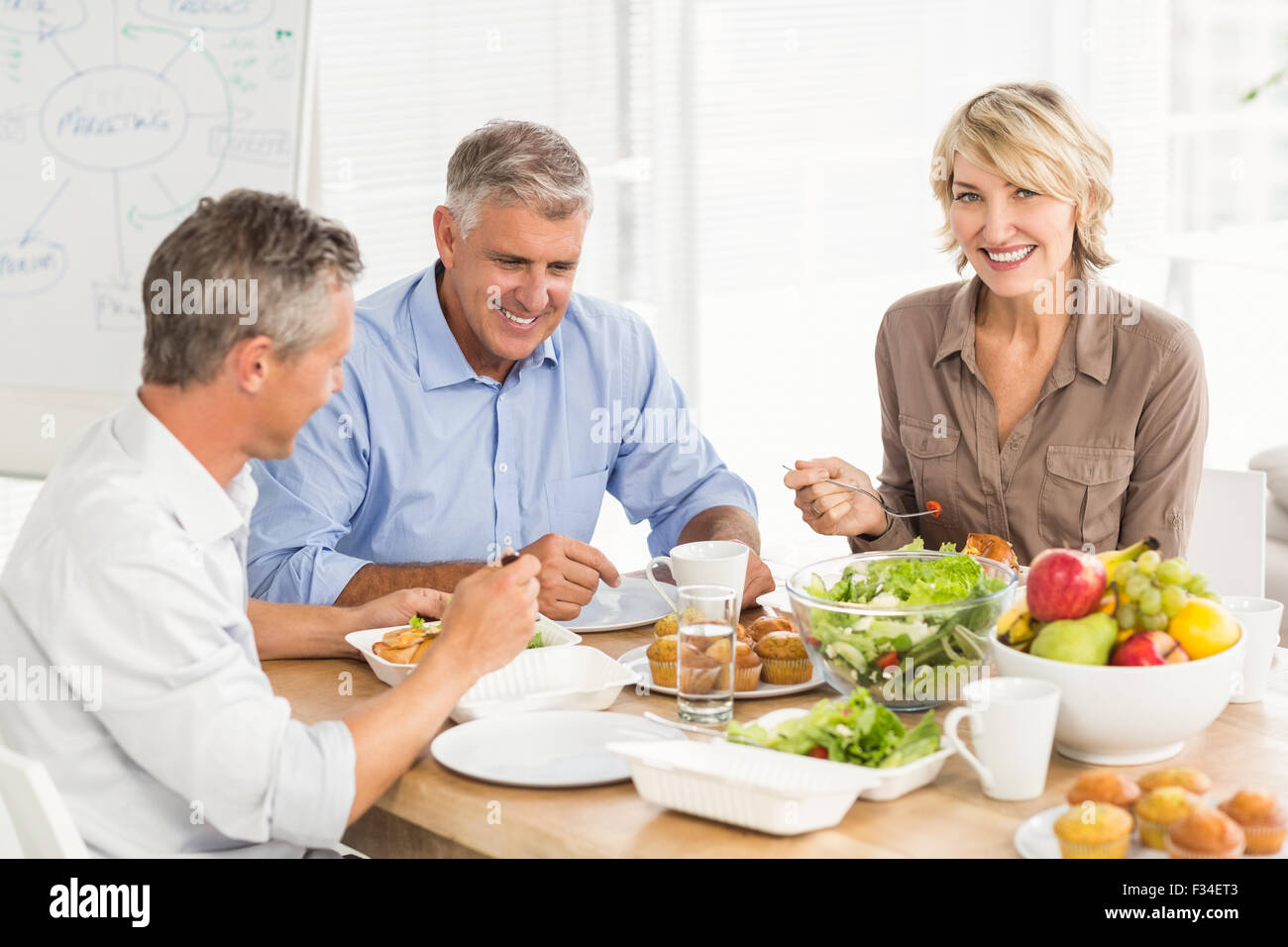 Smiling business colleagues having lunch together Stock Photo - Alamy
