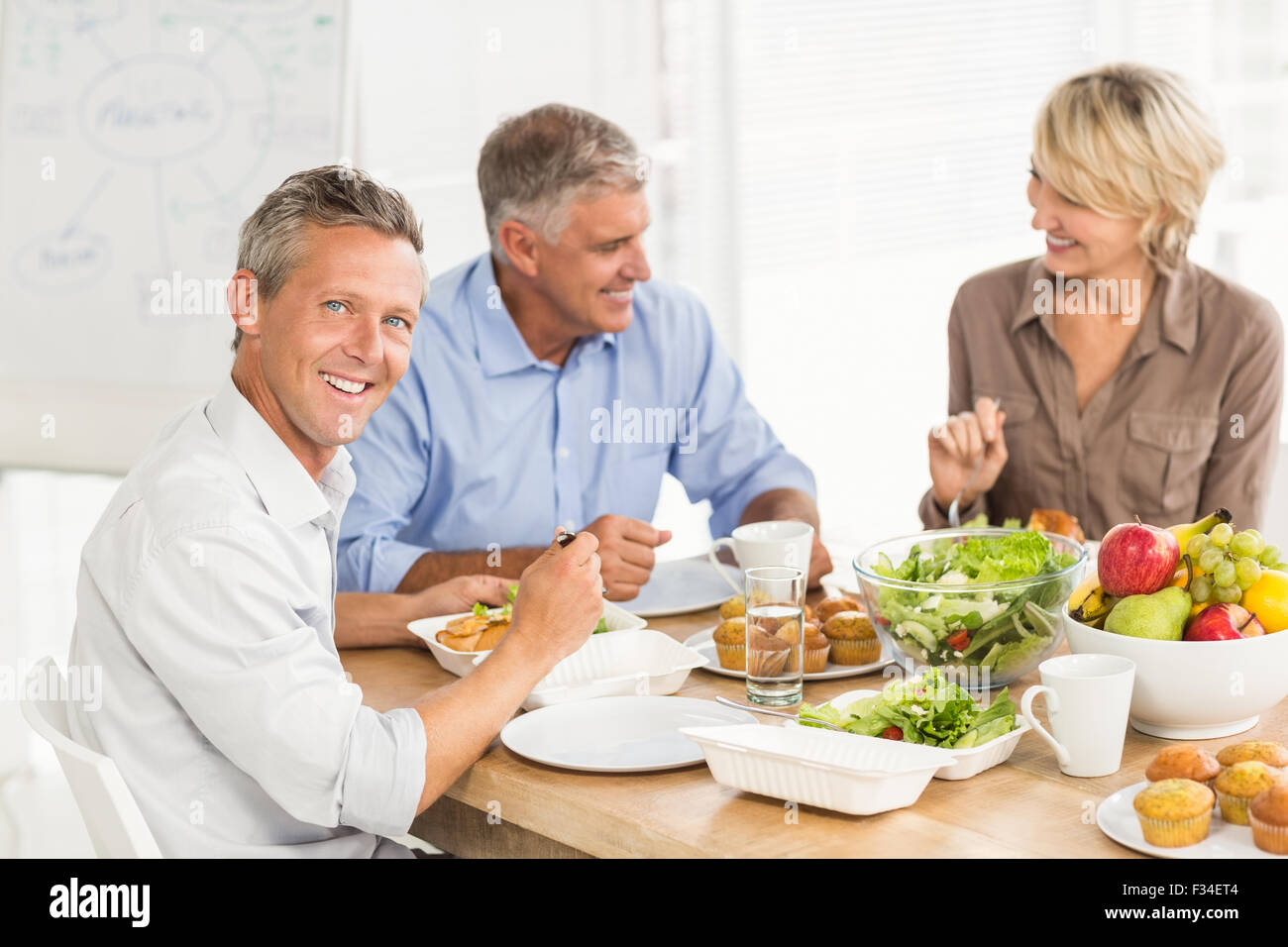 Smiling business colleagues having lunch together Stock Photo - Alamy