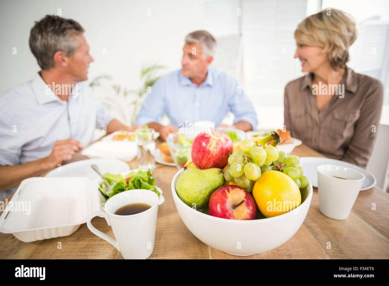 Smiling business colleagues having lunch together Stock Photo - Alamy