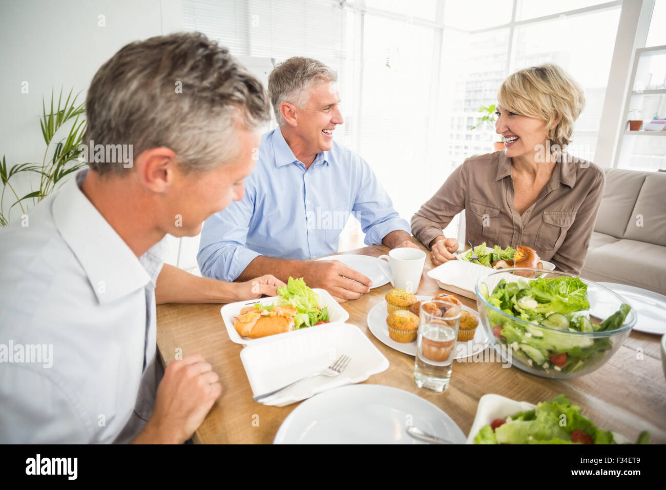 Smiling business people having lunch together Stock Photo - Alamy