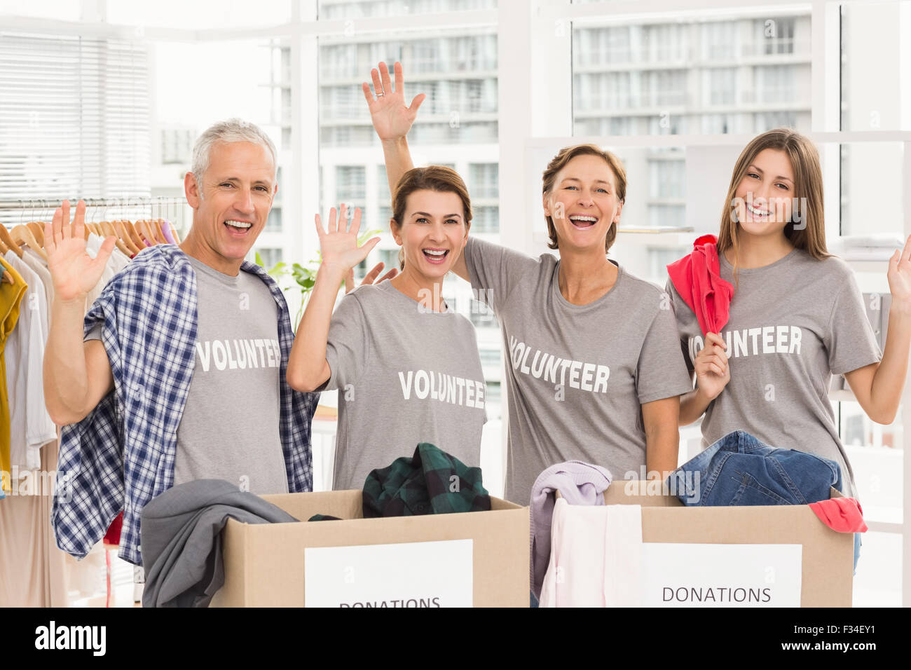 Smiling volunteers waving Stock Photo - Alamy
