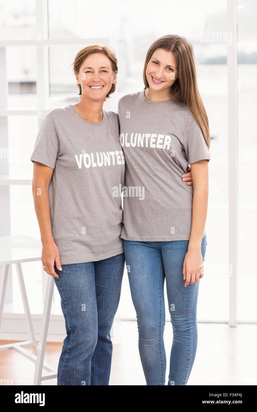 Smiling female volunteers putting arms around each other Stock Photo ...