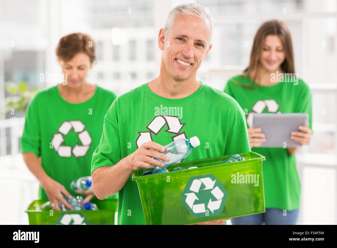 Smiling eco-minded man holding recycling box Stock Photo - Alamy
