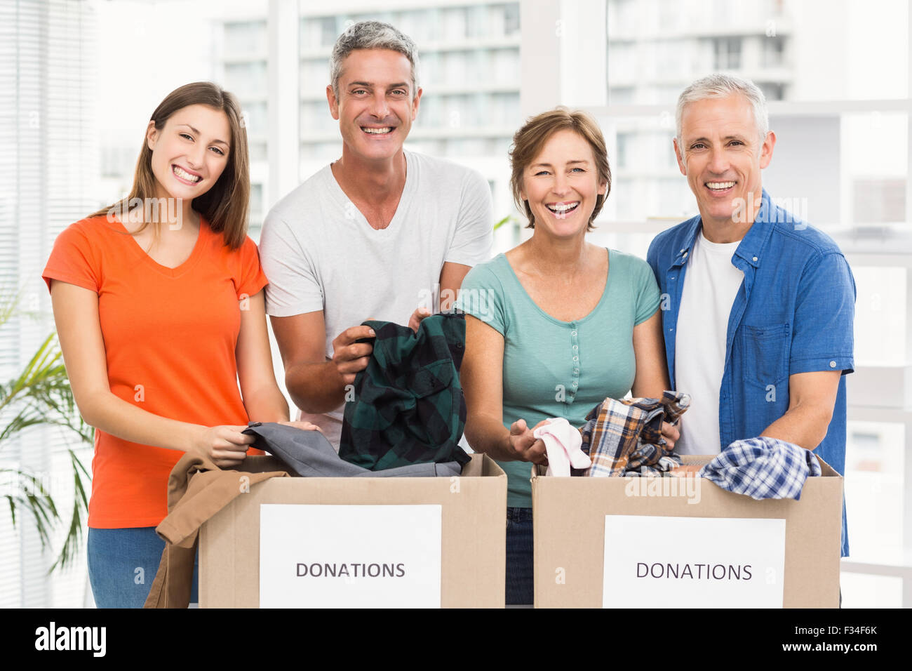 Smiling casual business people sorting donation boxes Stock Photo - Alamy