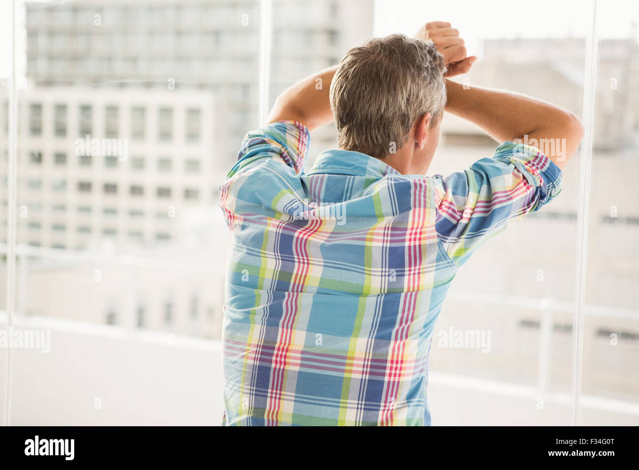 Rear view of troubled casual businessman leaning against window Stock ...
