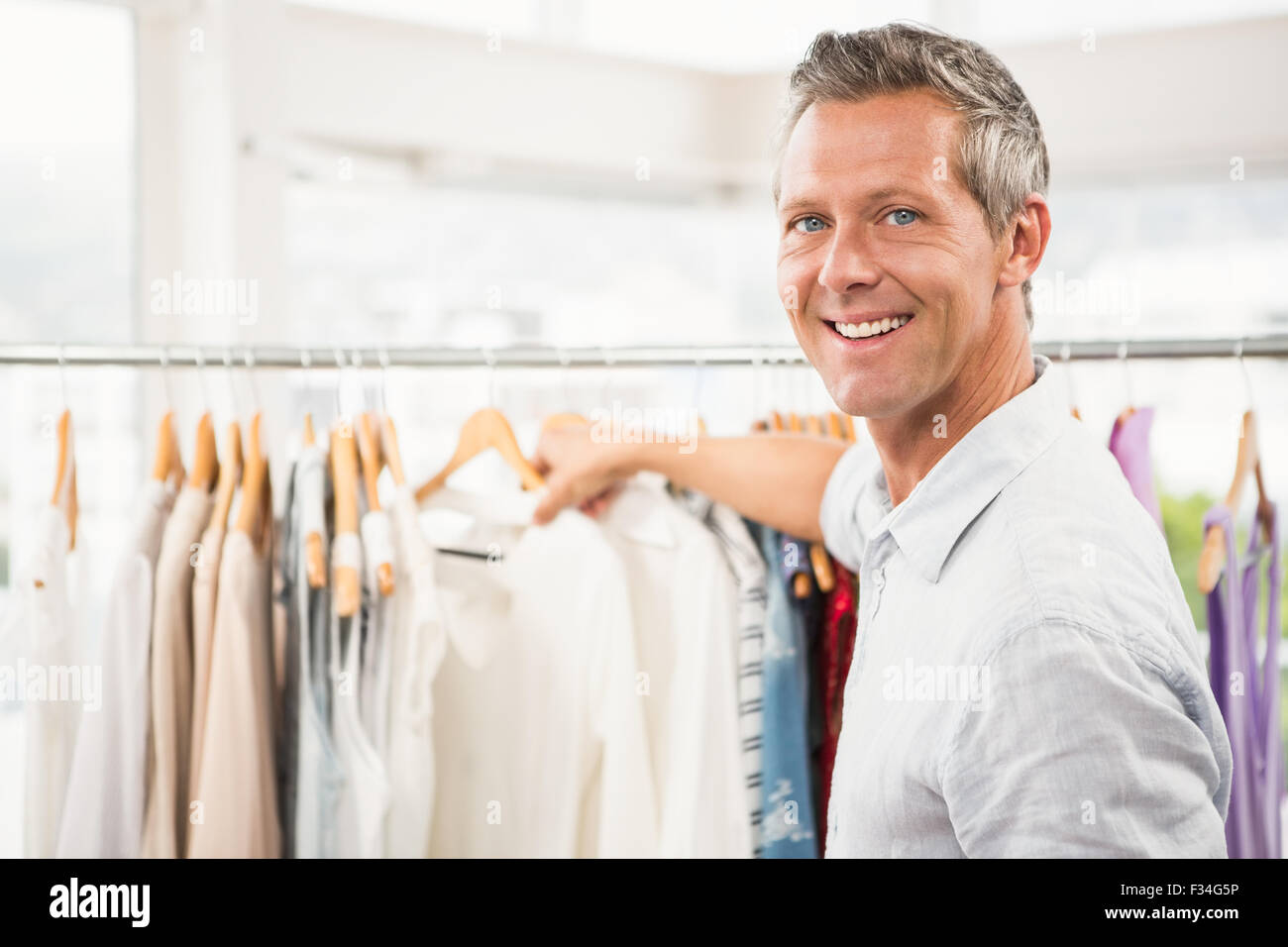Smiling man browsing clothes Stock Photo - Alamy