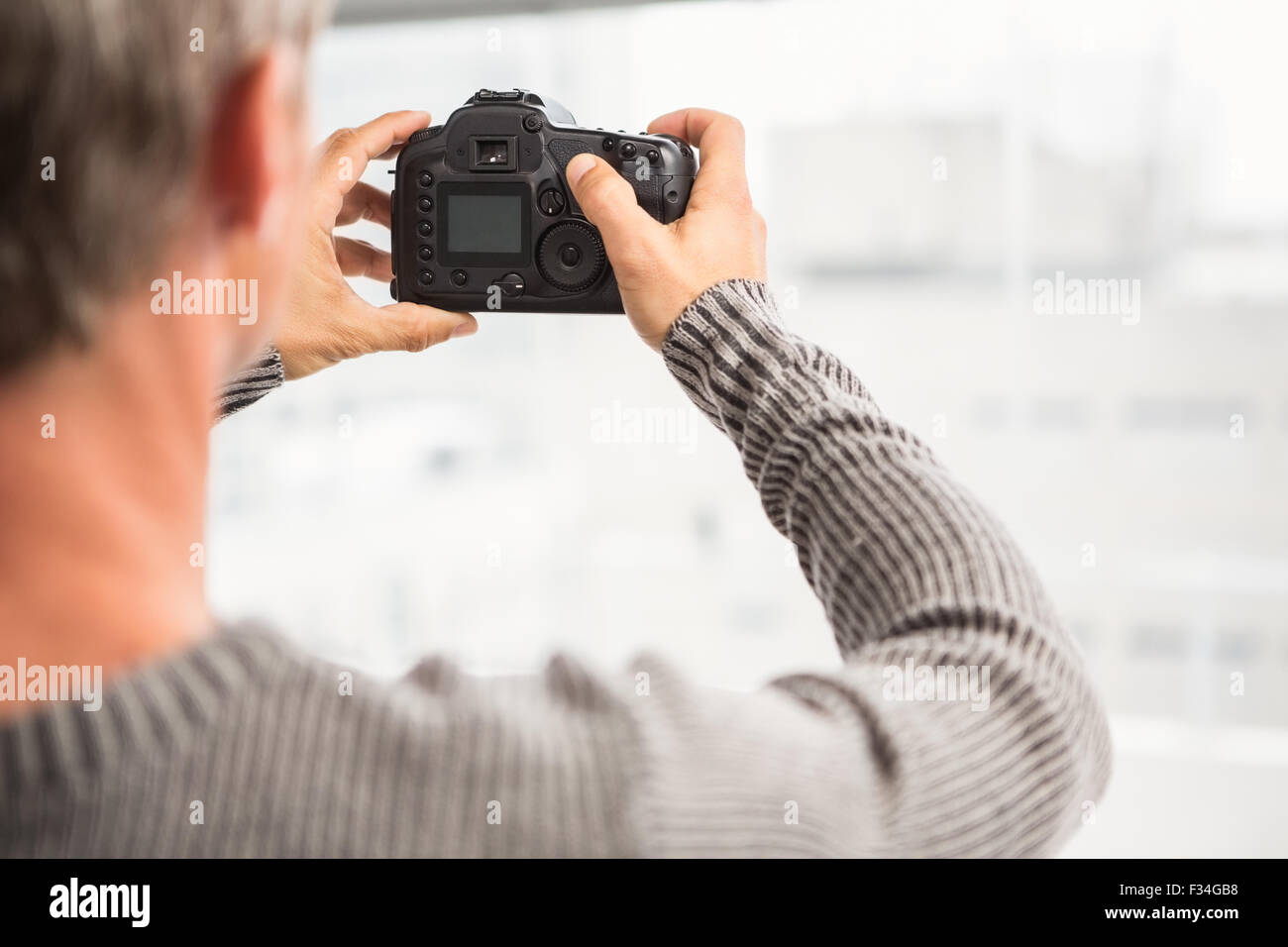 Rear view of man taking pictures with camera Stock Photo - Alamy