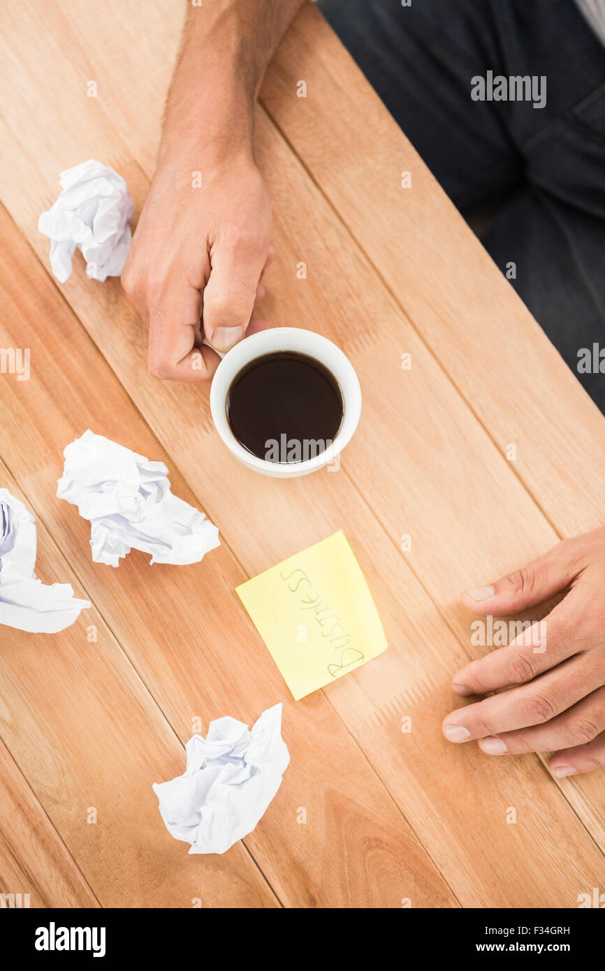 Hands holding coffee cup next to paper balls and sticky note Stock ...