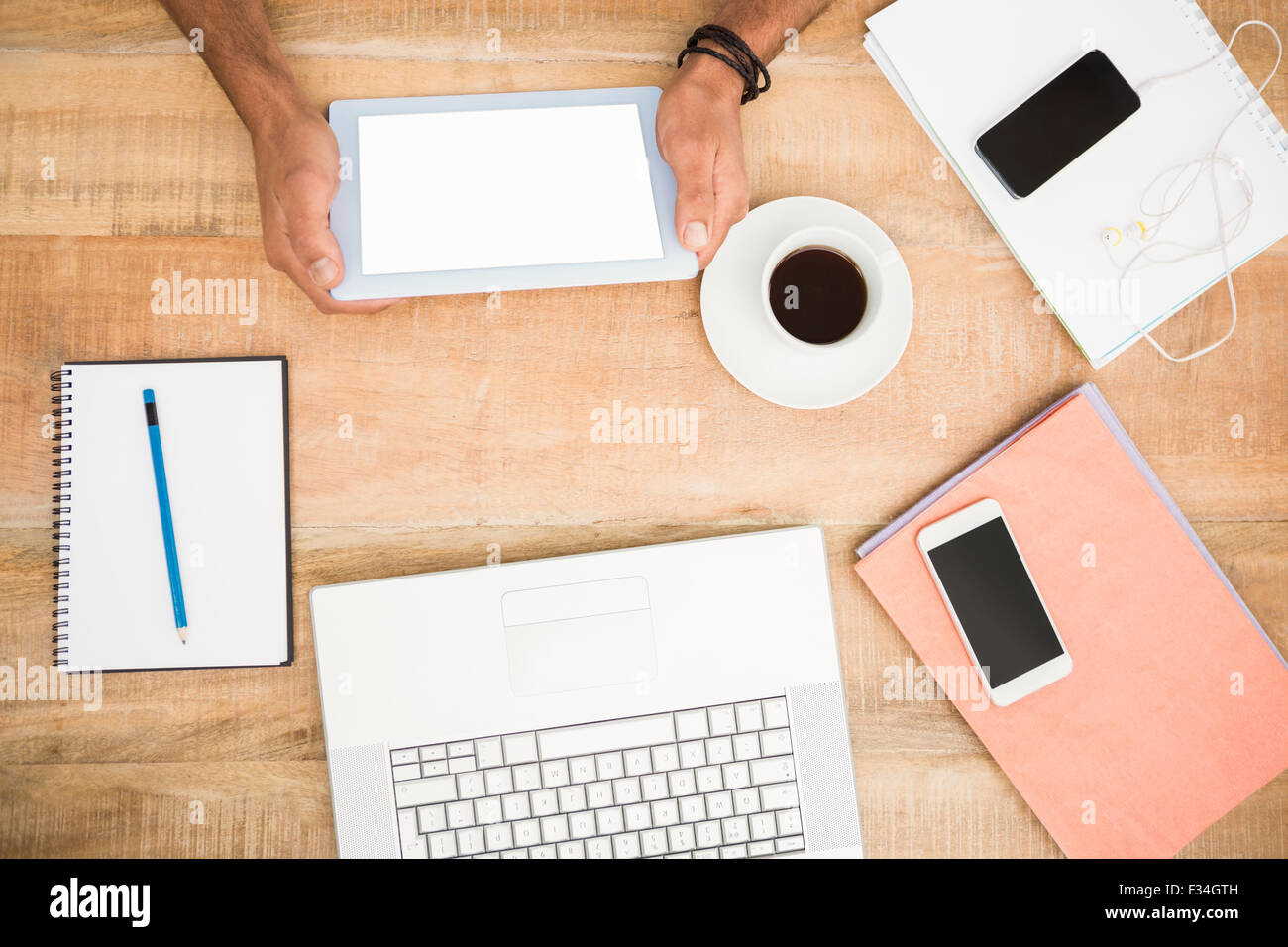 Hands holding tablet next to several devices Stock Photo - Alamy