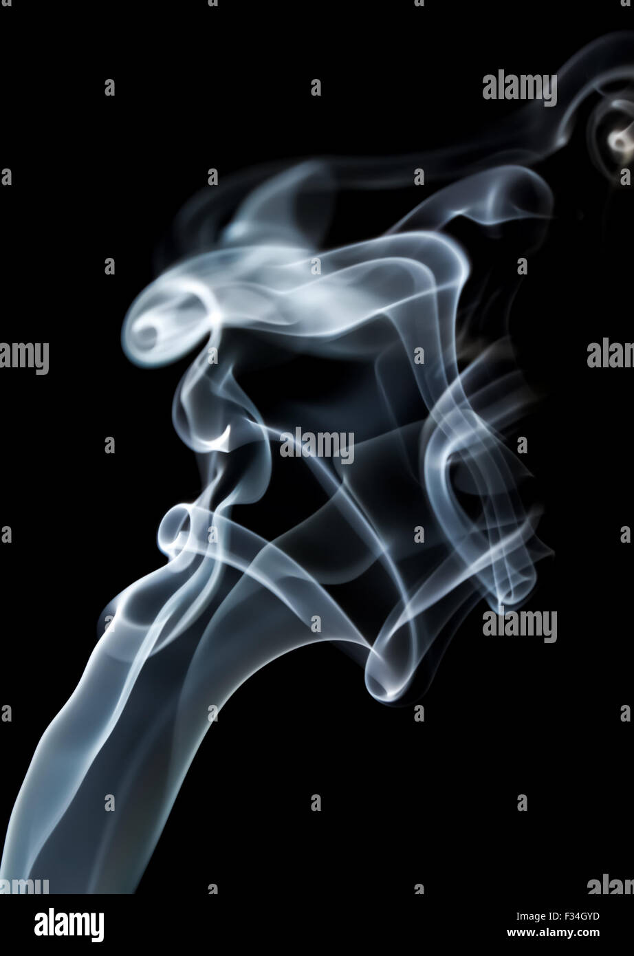 Abstract smoke swirls and waves on black background. Vertical shot ...