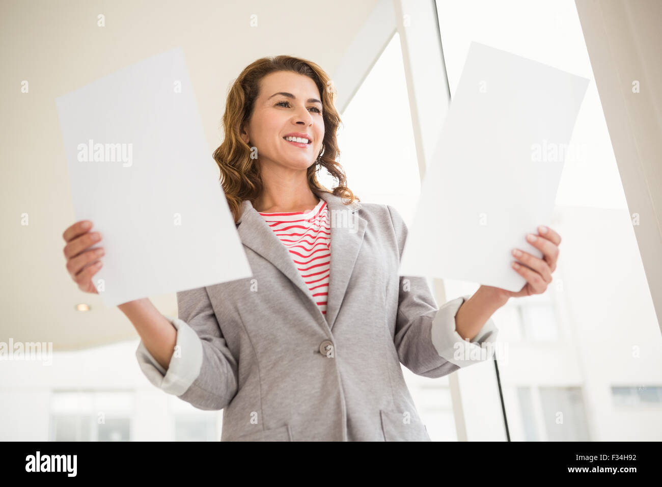Casual businesswoman holding papers Stock Photo - Alamy