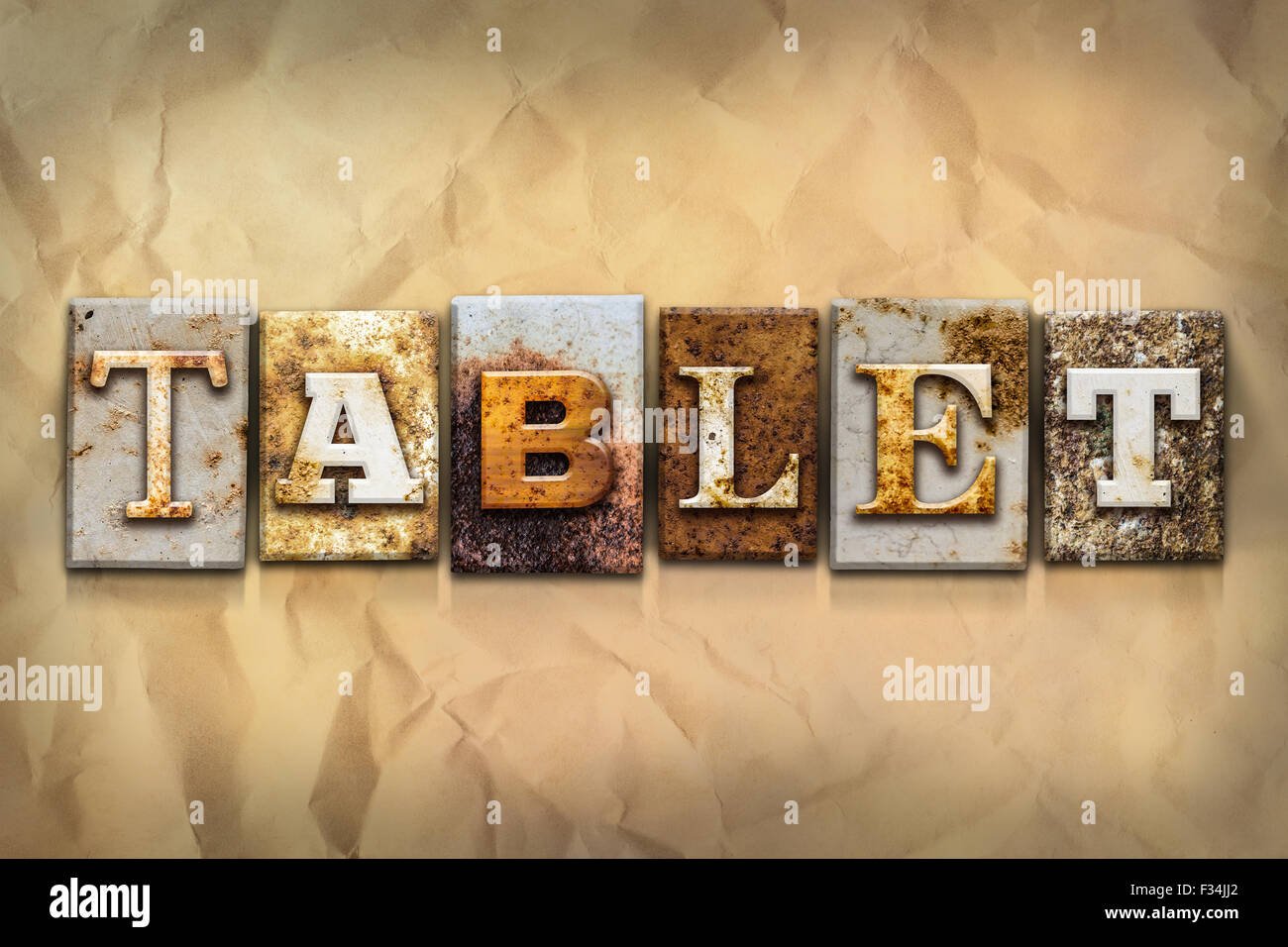 The word "TABLET" written in rusty metal letterpress type on a crumbled ...