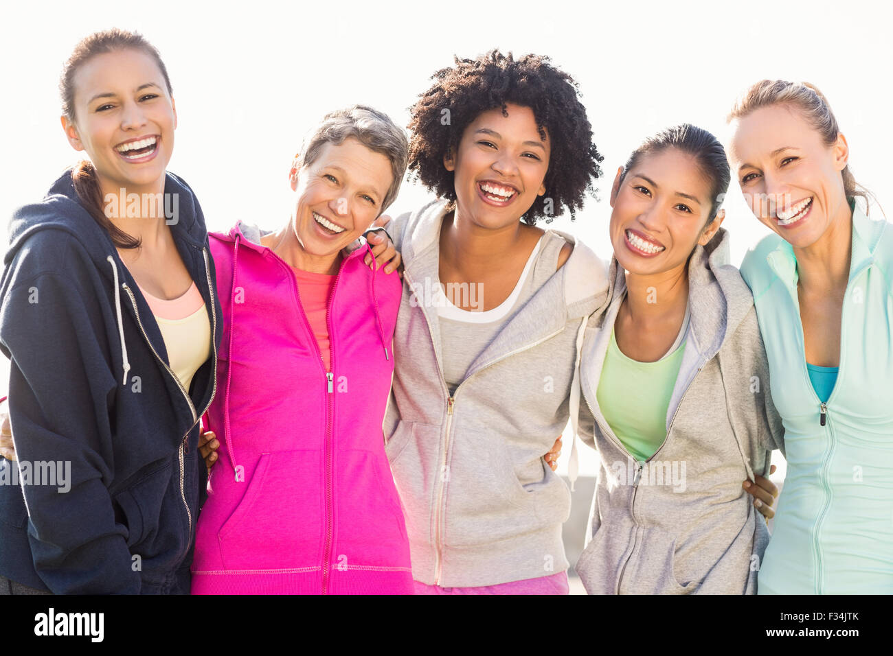 Laughing sporty women with arms around each other Stock Photo - Alamy