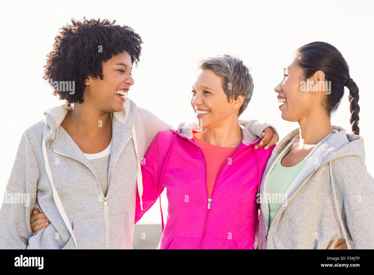 Laughing sporty women with arms around each other Stock Photo - Alamy