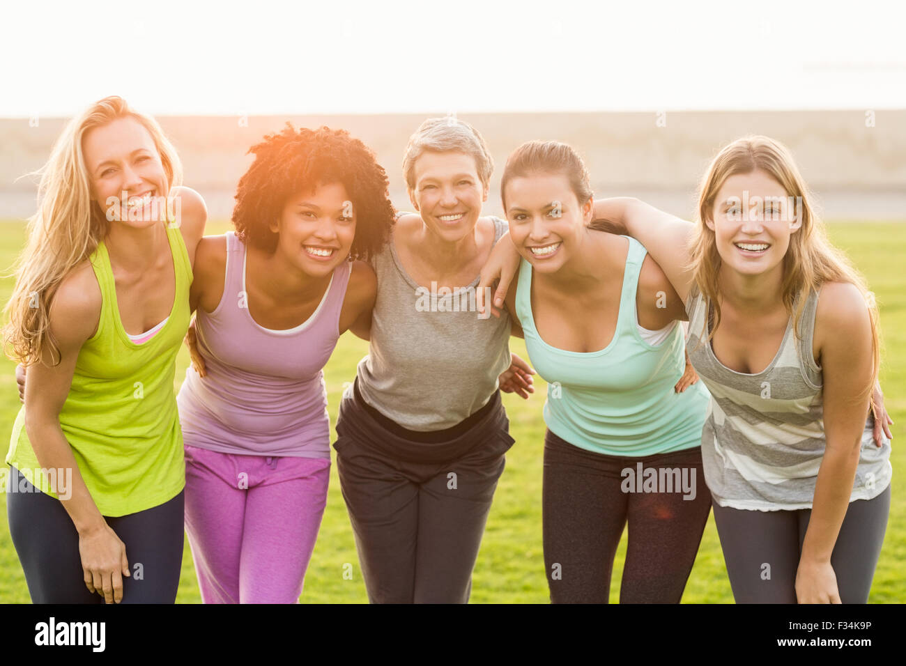 Smiling sporty women with arms around each other Stock Photo - Alamy