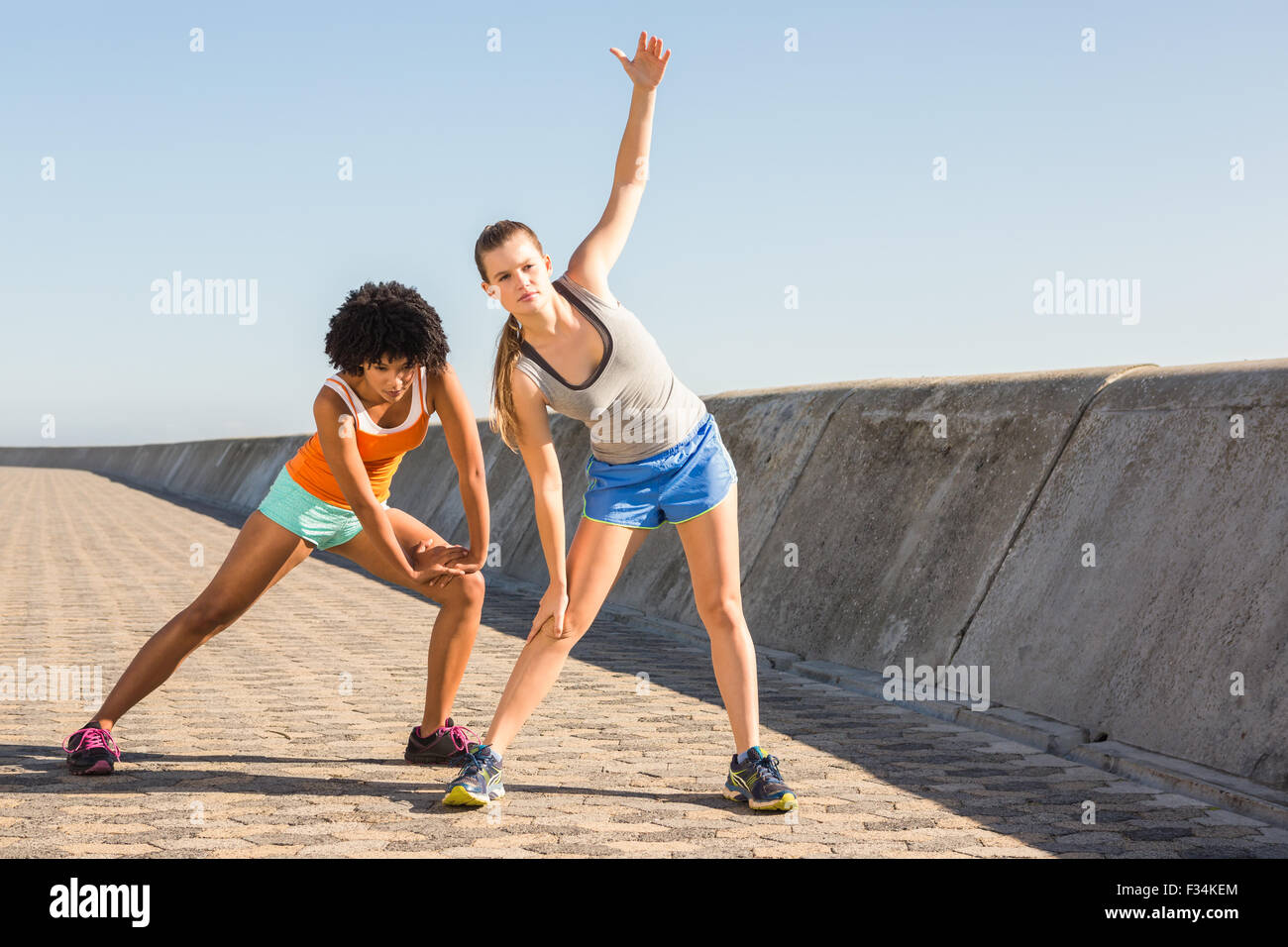 Two young woman stretching together Stock Photo - Alamy