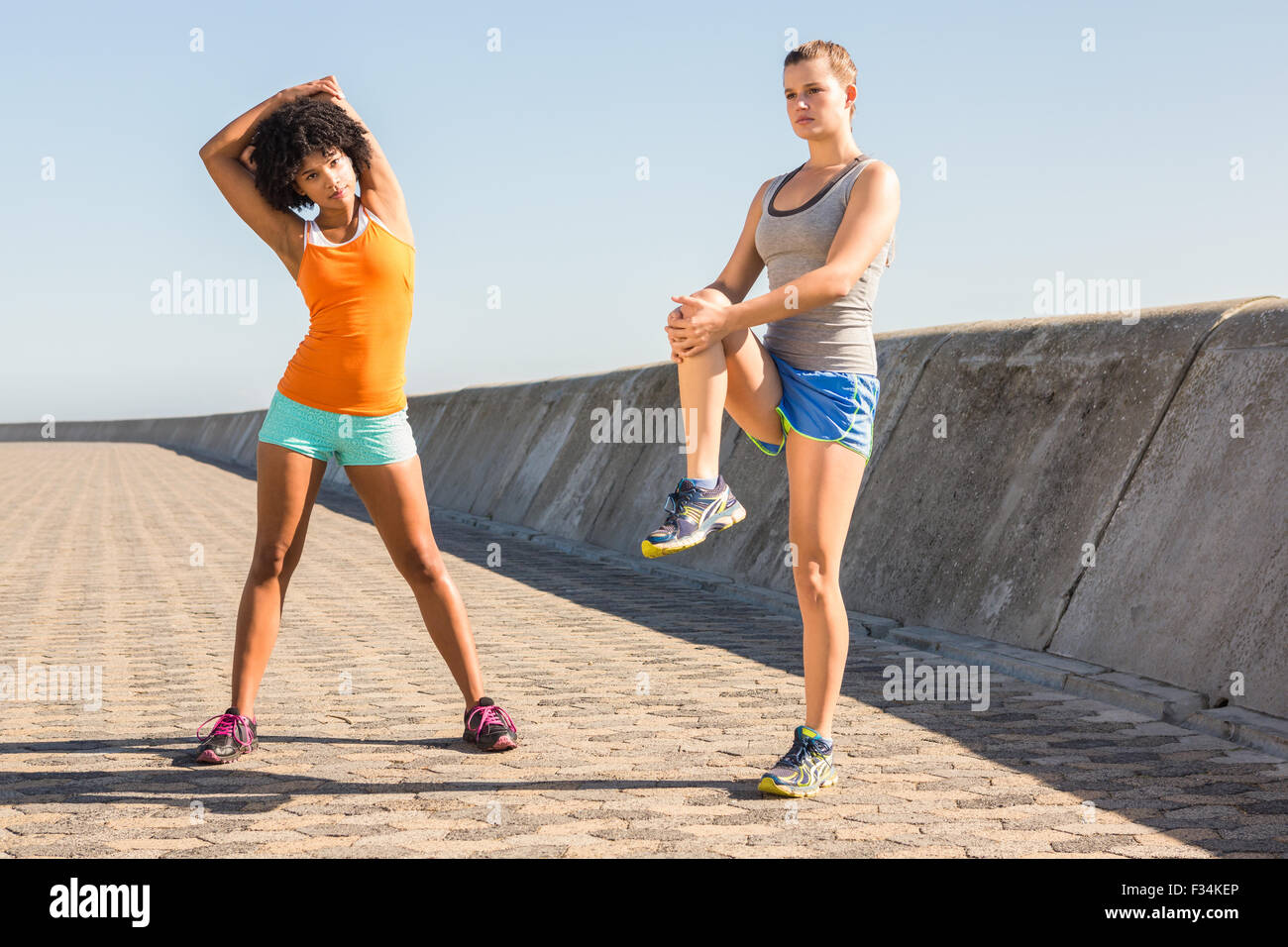 Two young woman stretching together Stock Photo - Alamy