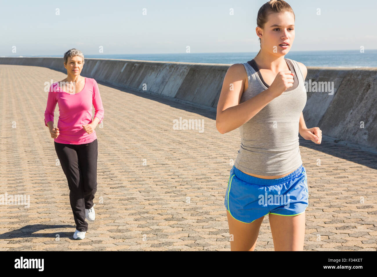 Two sporty women jogging together Stock Photo - Alamy