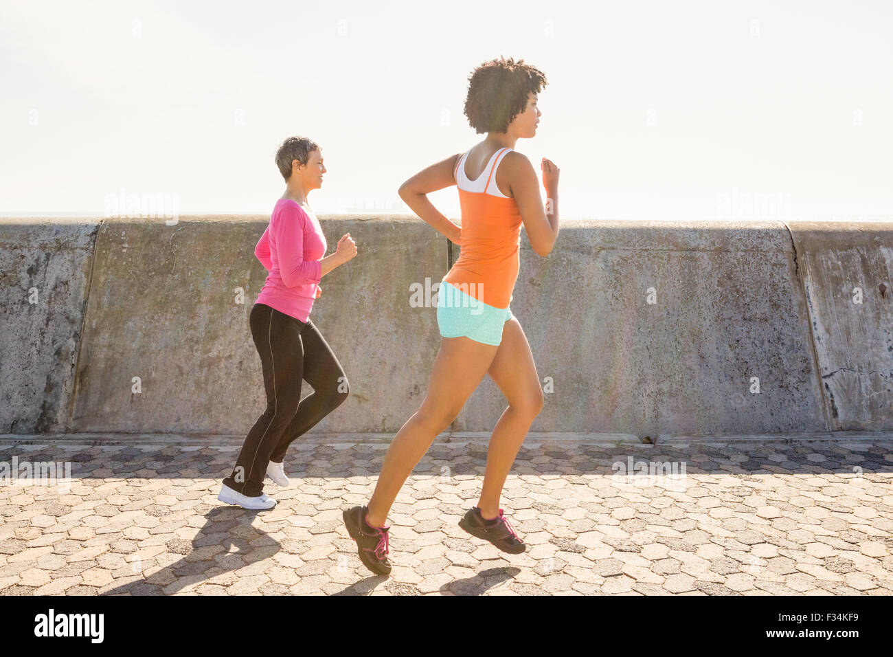 Two sporty women jogging together Stock Photo - Alamy