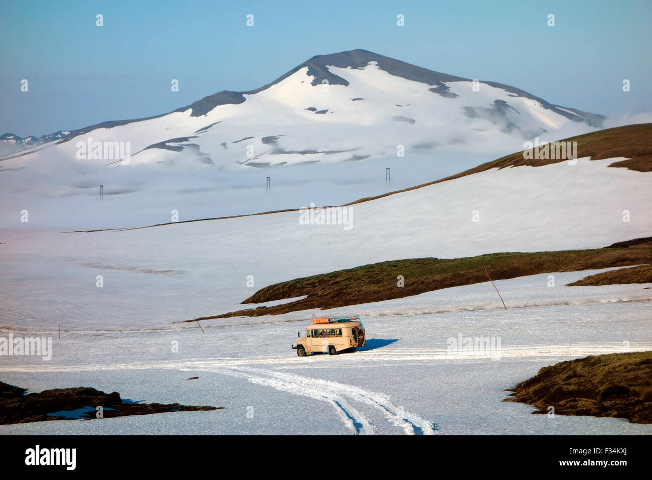 Tour bus on snow tracks on the way to Gorely volcano, Kamchatka ...
