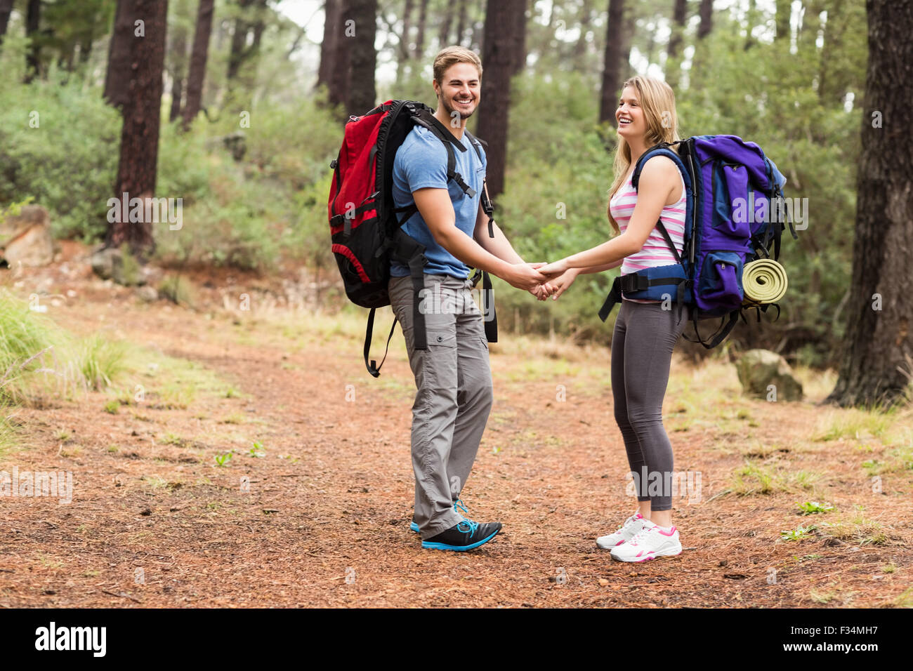 Young happy hiker couple holding hands Stock Photo - Alamy