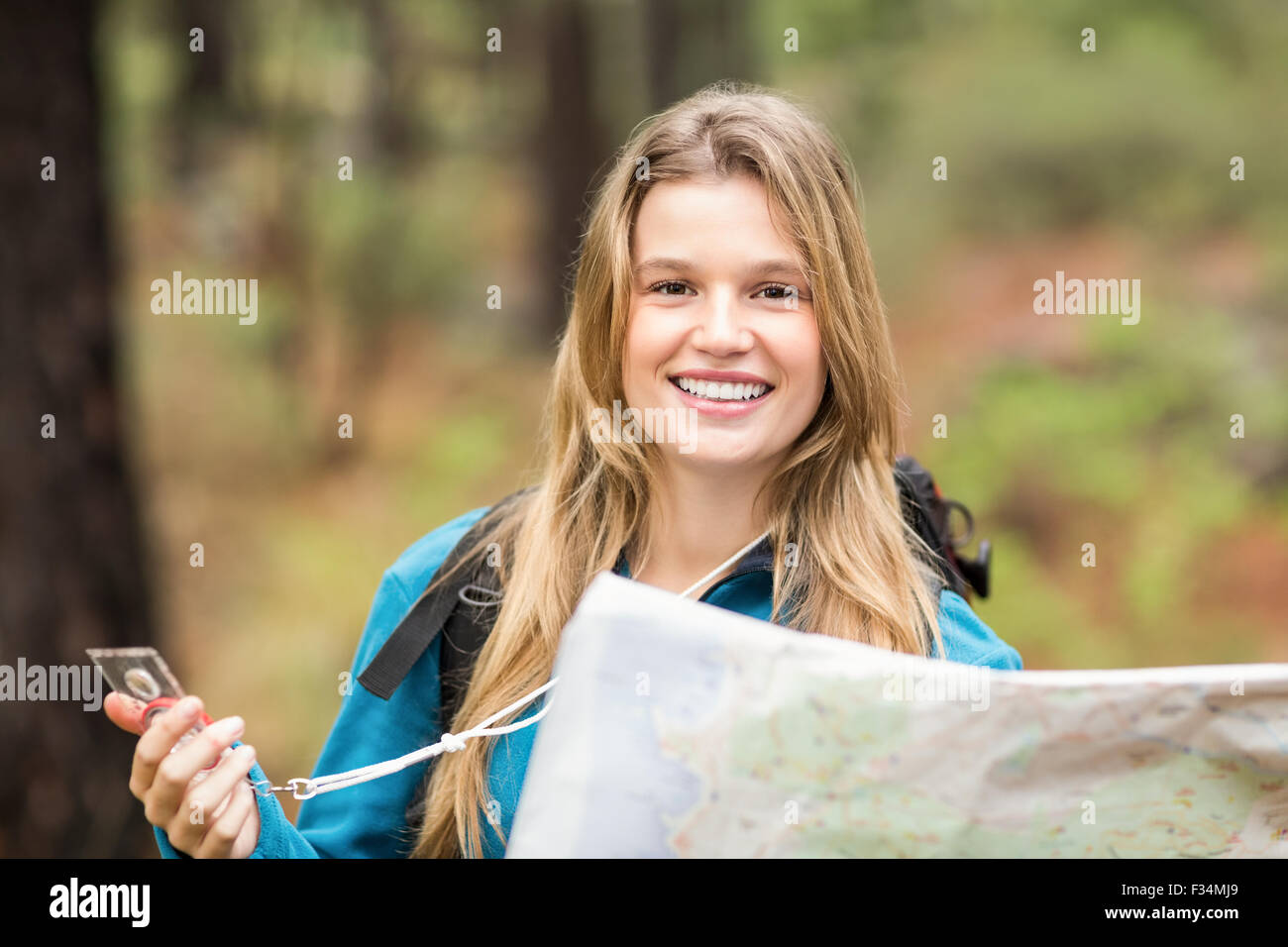 Young pretty hiker using compass and map looking at camera Stock Photo ...