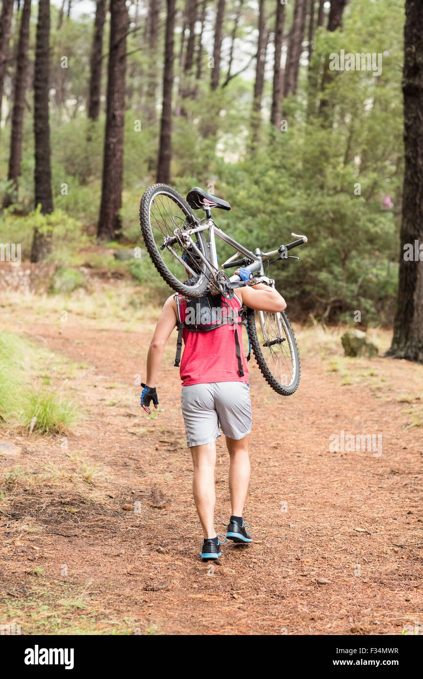 Happy handsome biker holding bike Stock Photo - Alamy
