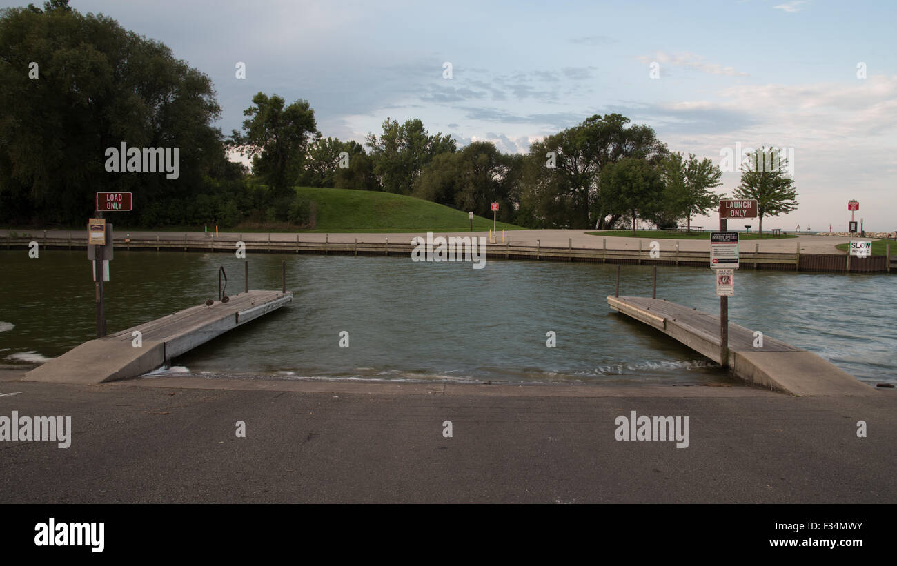 Waves lap at the concreate ramp at a boat launch. The landing is ...