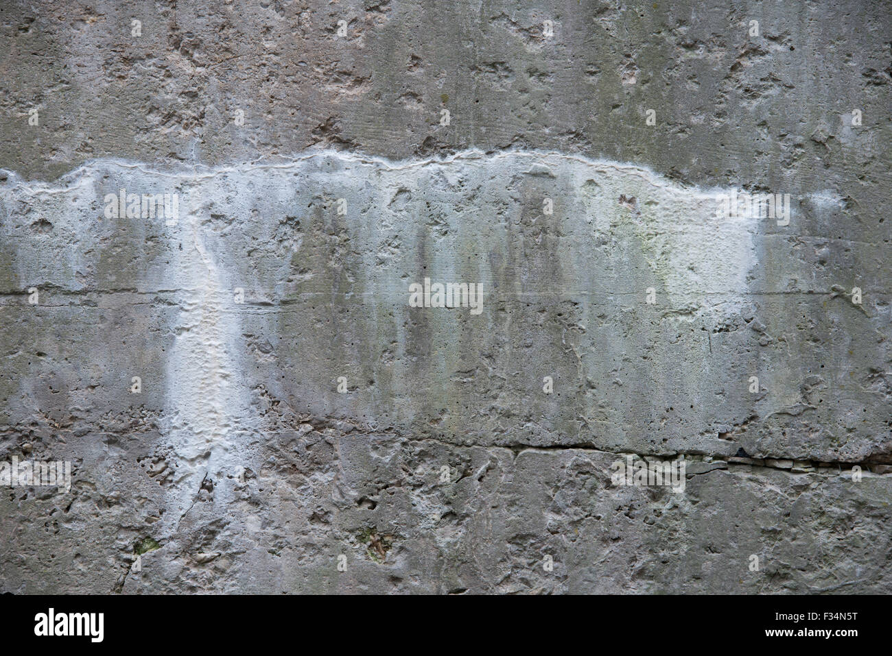 Minerals and salts leach out of the side of an old concrete wall ...