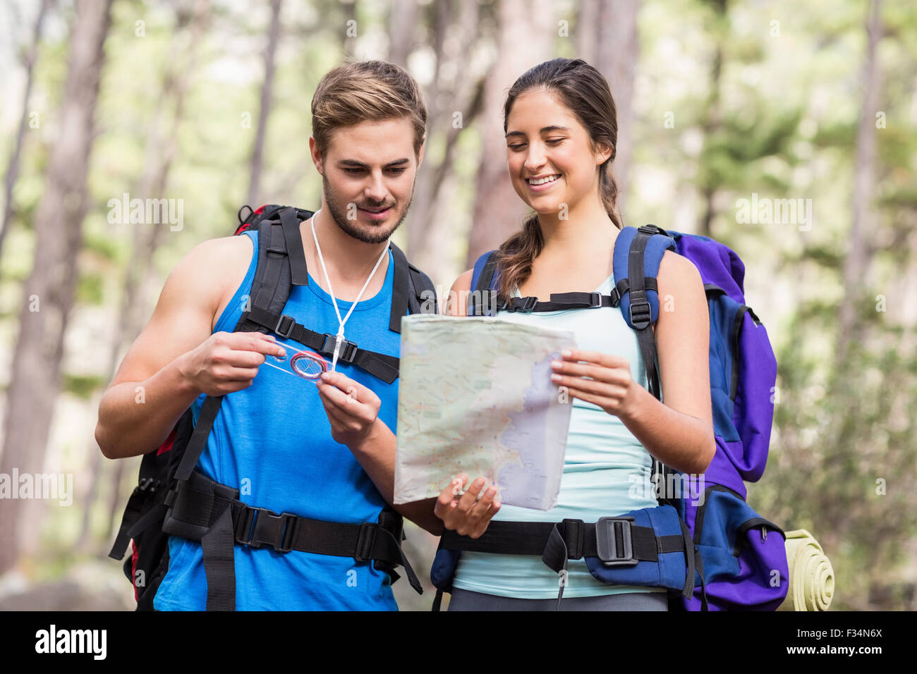 Happy hikers looking at map Stock Photo - Alamy