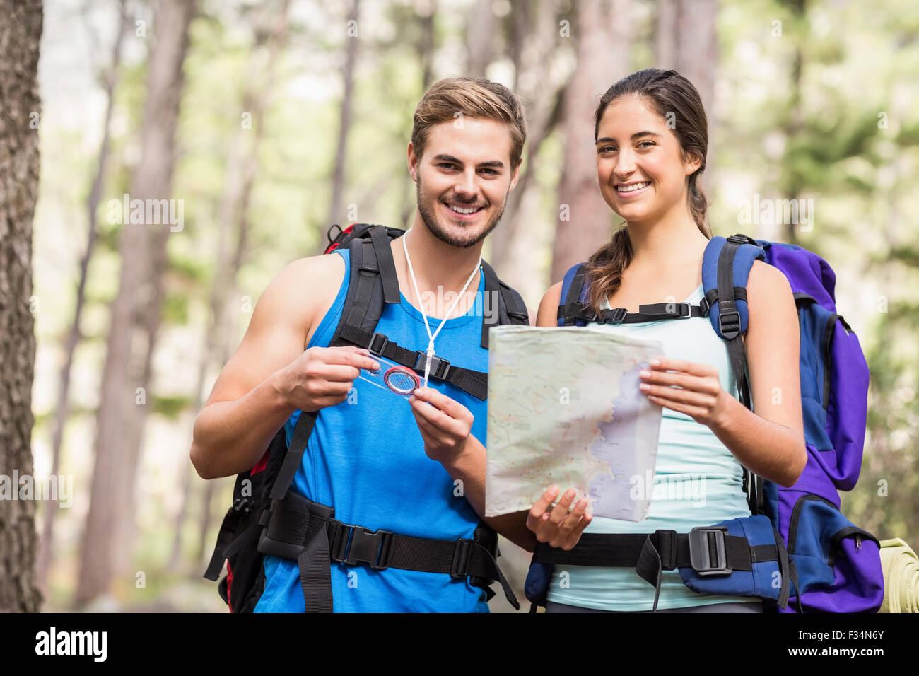 Happy hikers looking at camera holding map and compass Stock Photo - Alamy