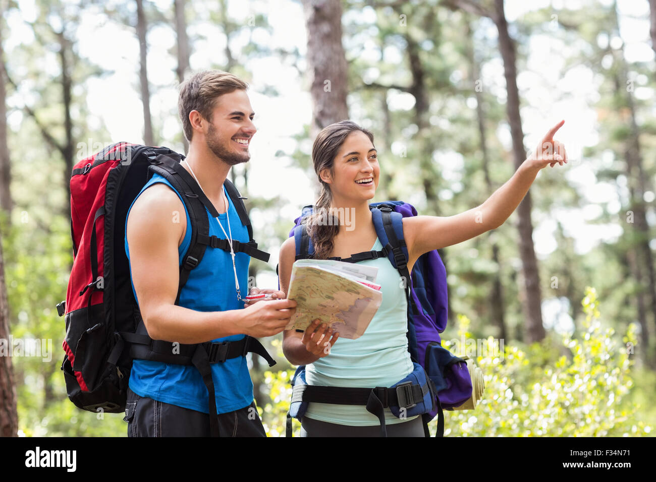 Happy hikers looking away holding map and compass Stock Photo - Alamy