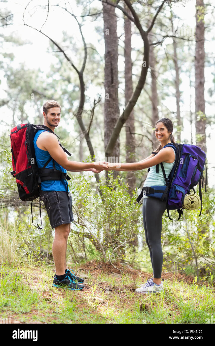 Happy hikers holding hands looking at camera Stock Photo - Alamy