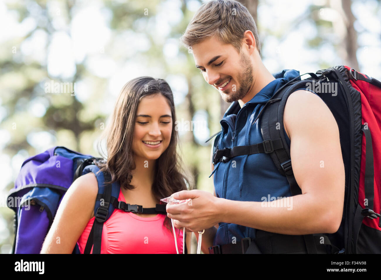 Young happy joggers looking at compass Stock Photo - Alamy