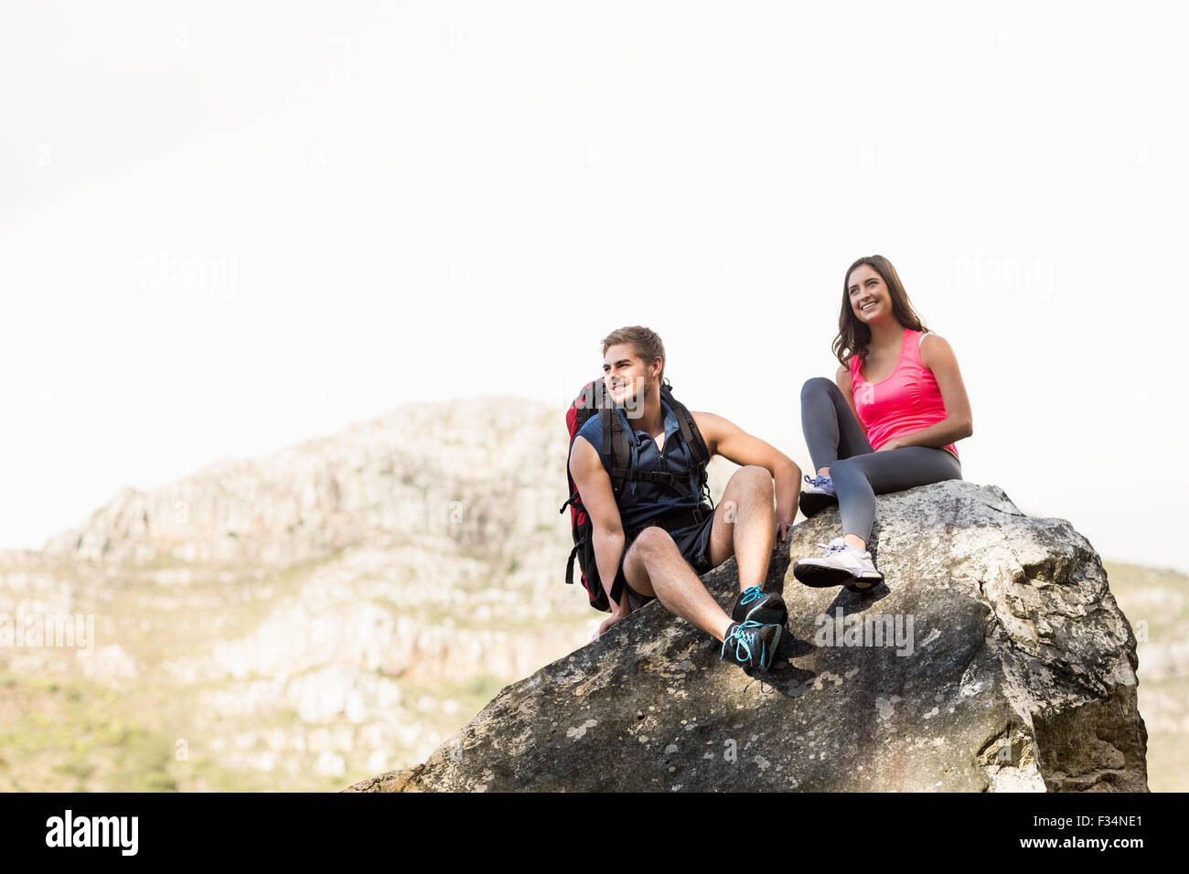 Young happy joggers sitting on rock Stock Photo - Alamy