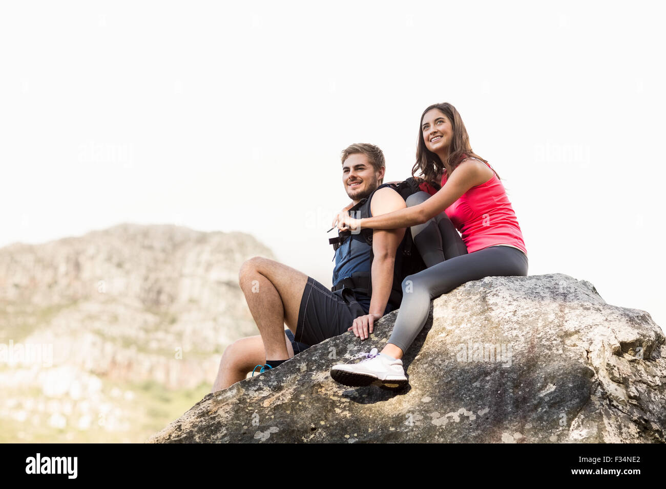 Young happy joggers sitting on rock Stock Photo - Alamy