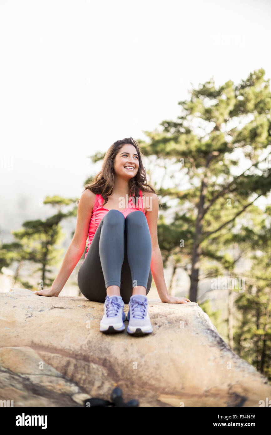 Young happy jogger sitting on rock looking away Stock Photo - Alamy