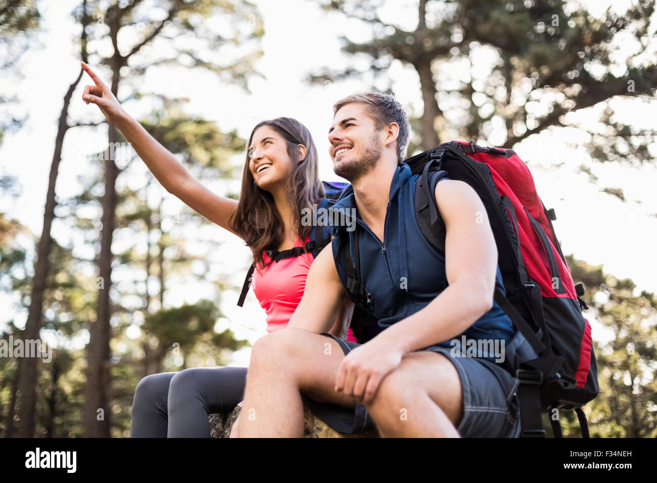 Young happy joggers sitting on rock and looking away Stock Photo - Alamy