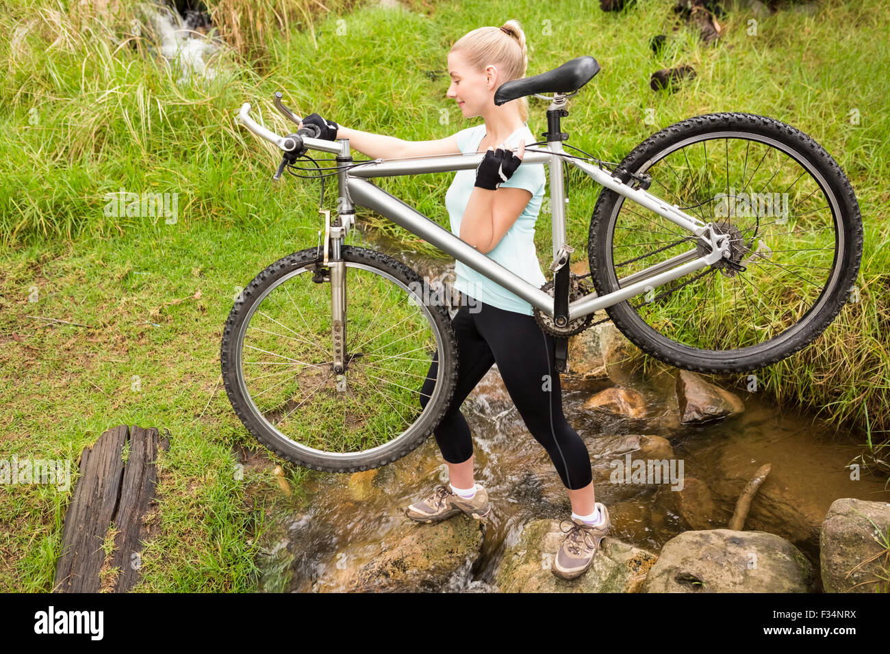 Serious fit woman lifting her bike Stock Photo - Alamy