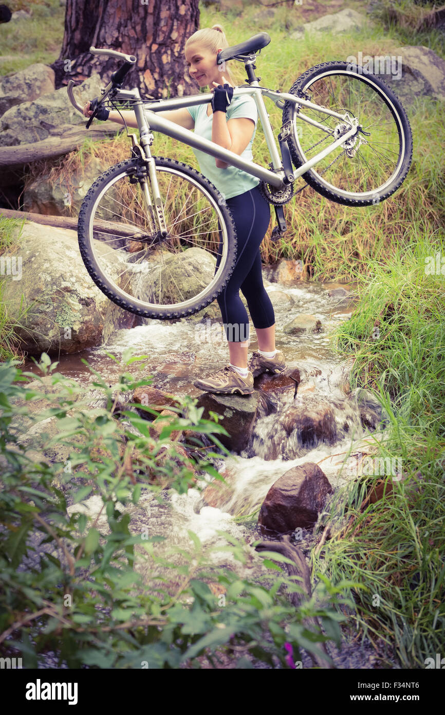 Serious fit woman lifting her bike Stock Photo - Alamy