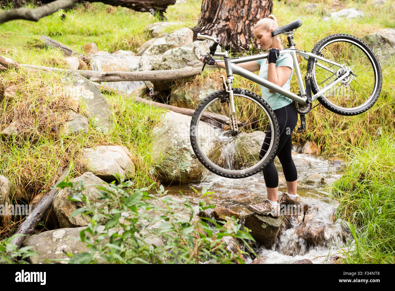 Serious fit woman lifting her bike Stock Photo - Alamy