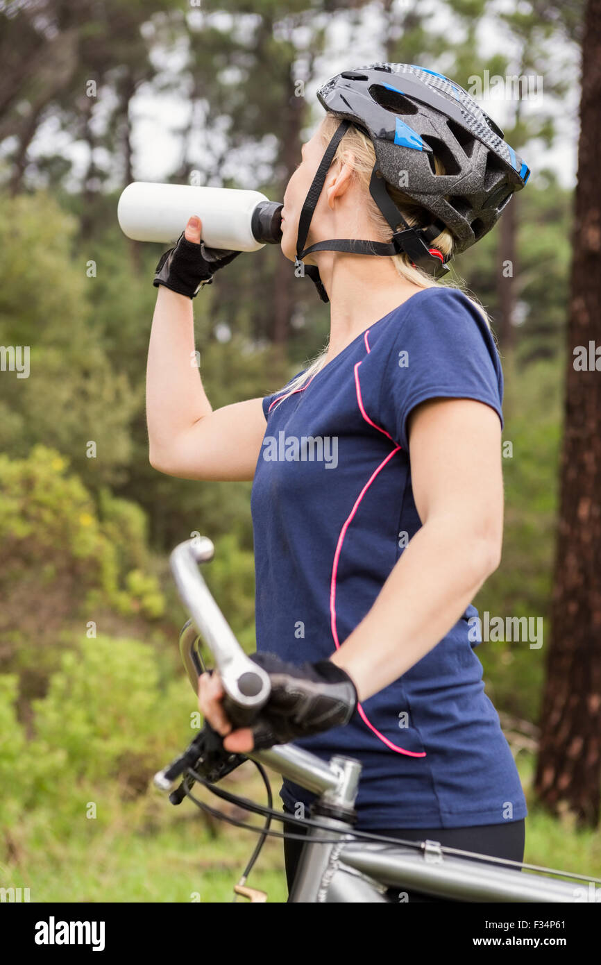 Athletic blonde drinking and holding mountain bike Stock Photo - Alamy