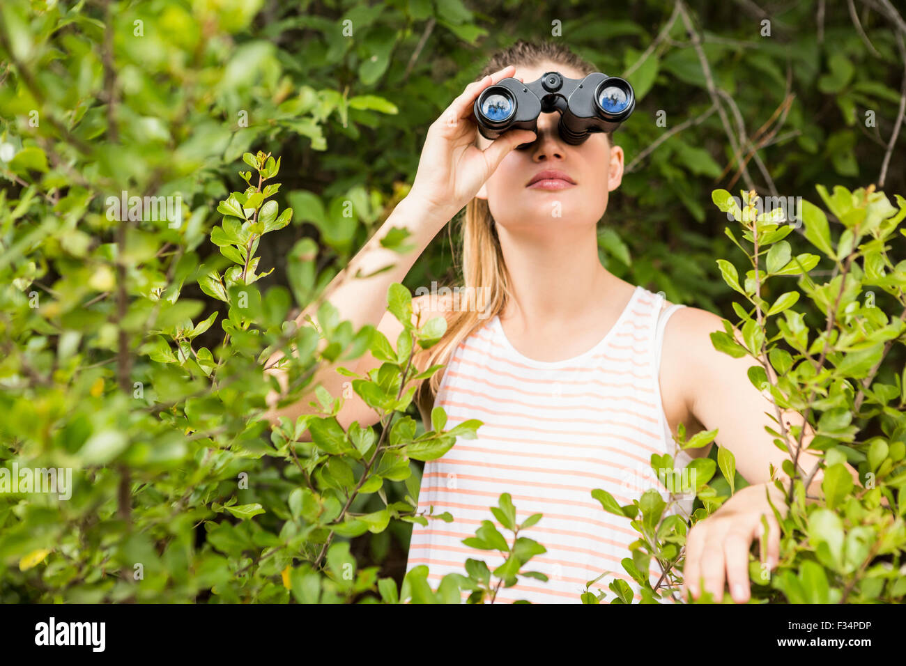Pretty blonde looking through binoculars Stock Photo - Alamy