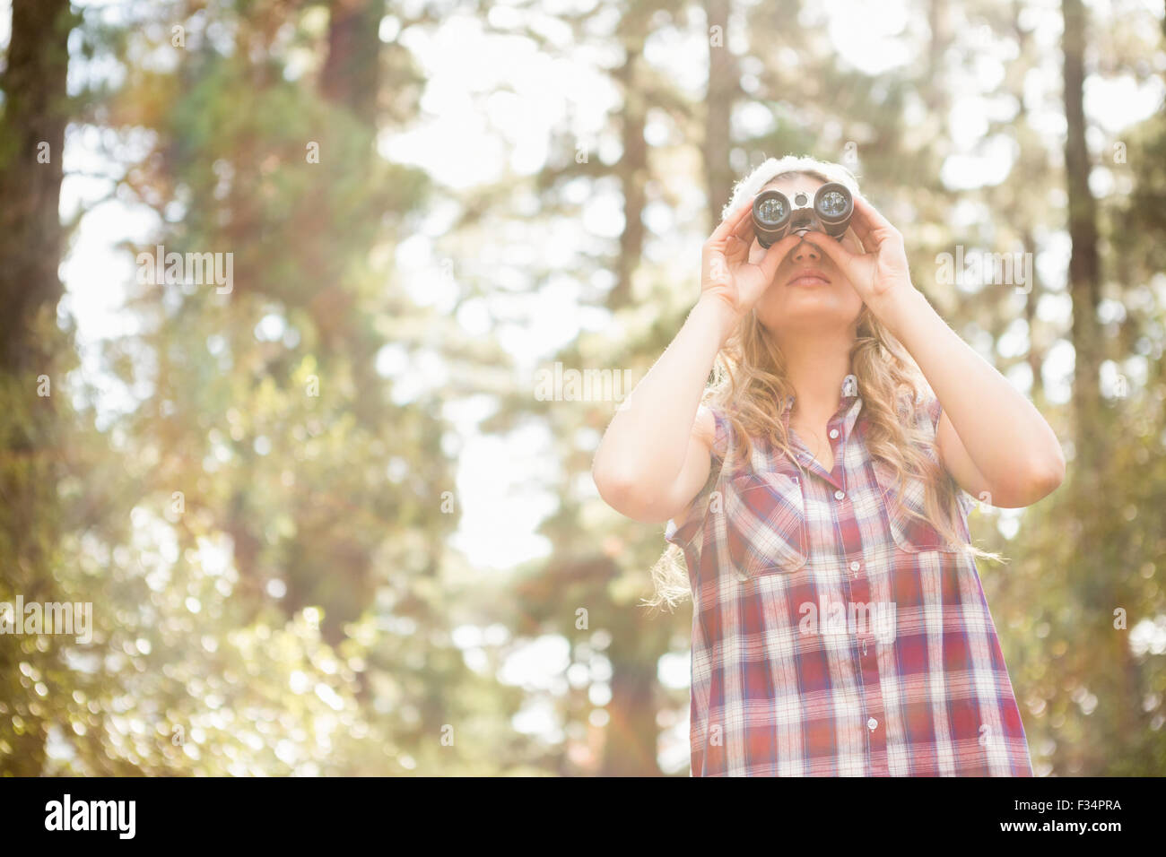 Pretty young blonde looking through binoculars Stock Photo - Alamy