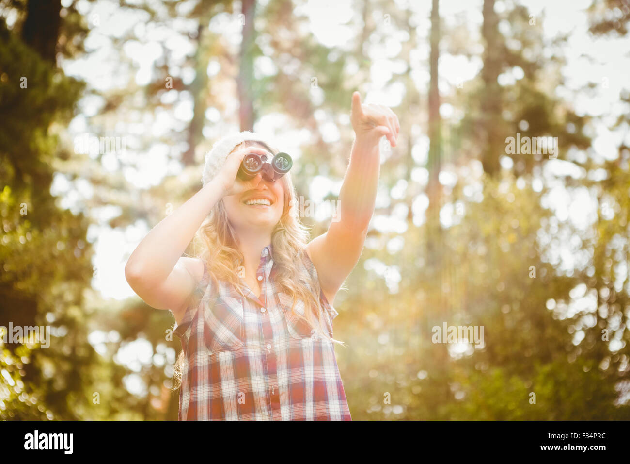 Pretty young blonde looking through binoculars Stock Photo - Alamy